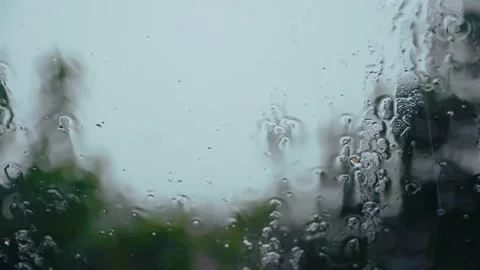 Raindrops falling down on glass of windo... | Stock Video | Pond5