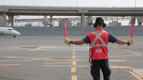 Ramp Worker Uses Safety Baton to Direct ... | Stock Video | Pond5