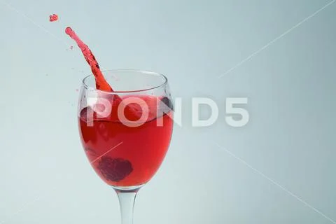 Raspberry splashing into glass of wine red juice drink splash water ...