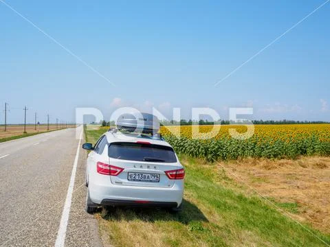 Photograph: Rear view of a white Lada Vesta car with a roof box on the ...