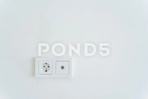 A rectangular white wall socket with a power plug and socket for ...