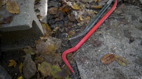 Red and black crowbar laid on dirty grou... | Stock Video | Pond5
