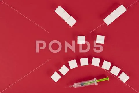 Photograph: On a red background, cubes of white sugar in the form of an ...