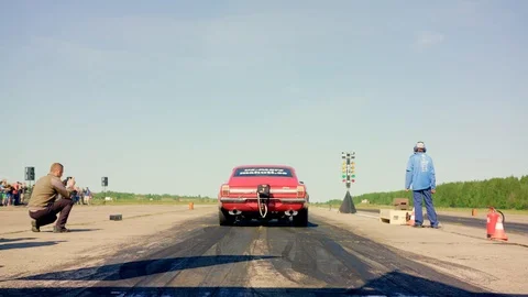 Red car takes off down the drag strip | Stock Video | Pond5