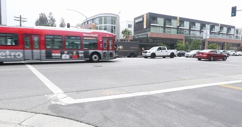 Red city bus crossing an intersection fr... | Stock Video | Pond5