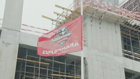 Red flag with logo waving in wind at con... | Stock Video | Pond5