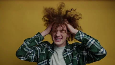 A red-haired curly guy ruffles his hair ... | Stock Video | Pond5