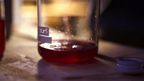 red liquid is poured into a beaker and s... | Stock Video | Pond5