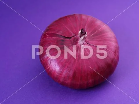 A red onion on a purple background. ~ Premium Photo #260822334