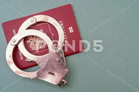 Photograph: Red passport and handcuffs on a green background #156266962