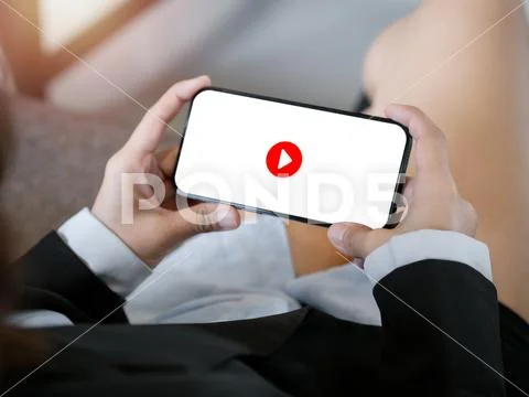 Red play button icon on white screen background on mobile smart phone ...