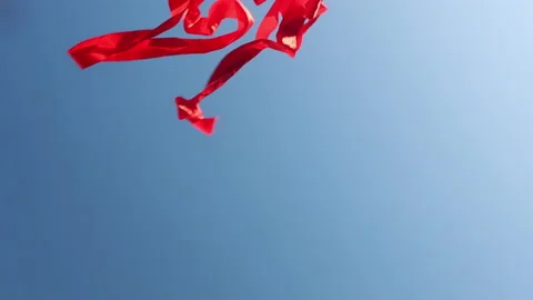 The red ribbon slowly falls on a backgro... | Stock Video | Pond5