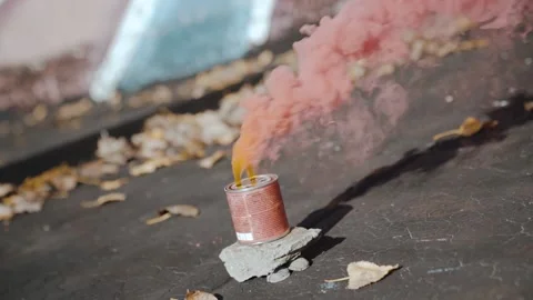 Red Smoke Flare on the Ground in front o... | Stock Video | Pond5