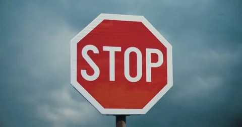 Red stop sign with stormy sky | Stock Video | Pond5