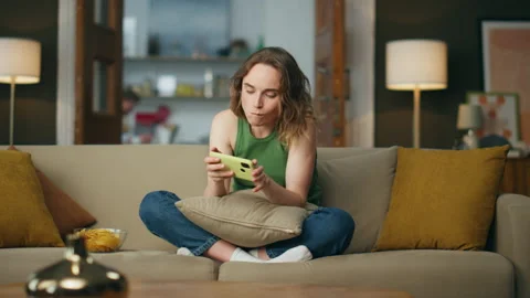 Relaxed girl eating snacks at cozy couch... | Stock Video | Pond5