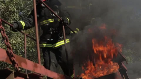 Rescuers walk through fire and smoke on ... | Stock Video | Pond5