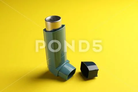 Photograph: Respiratory problem. Asthma inhaler on yellow background ...