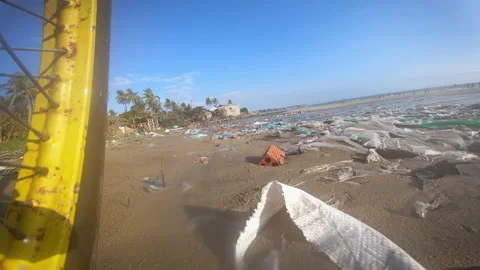 Riding Bike Through Trash on the Beach | Stock Video | Pond5