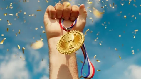Rising hand holding a shiny gold medal. ... | Stock Video | Pond5
