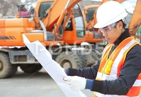 Road construction worker with heavy equipment on the background ...
