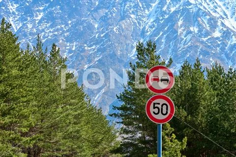 Road sign of speed limit and prohibiting overtaking on a serpentine ...