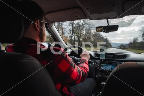 Photograph: Road trip concept man driving car by highway inside view ...