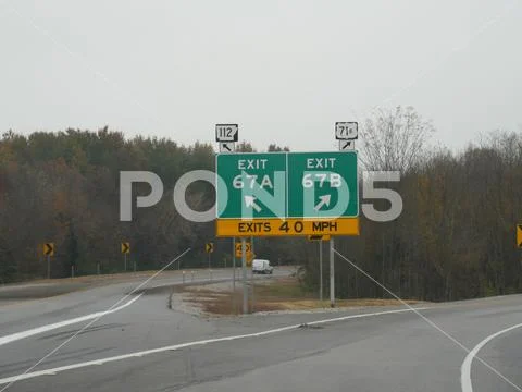Photograph: Roadside signs and speed limit sign at a fork in the roads ...