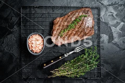 Roasted medium rare flank beef steak with thyme. Black background. Top ...