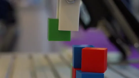 A robotic arm moves a cube-shaped part. | Stock Video | Pond5