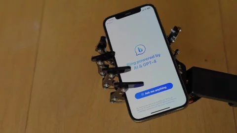 Robotic hand holds a phone with an artif... | Stock Video | Pond5