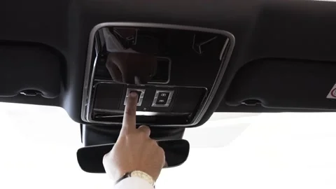 roof-mounted buttons to open sunroof, ra... | Stock Video | Pond5