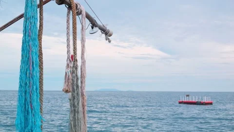 Ropes and fishing nets hang over sea sur... | Stock Video | Pond5