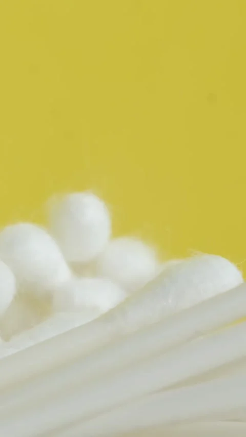Rotating cotton swabs on a yellow chroma... | Stock Video | Pond5