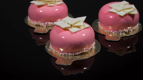 Rotating pink pastry cakes sweets on bla... | Stock Video | Pond5