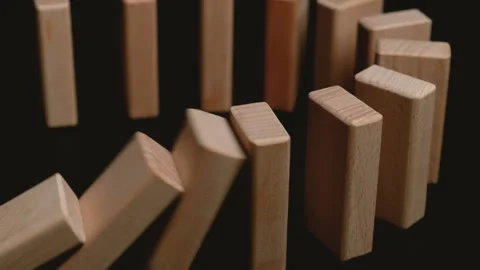Row of wooden domino falling down agains... | Stock Video | Pond5