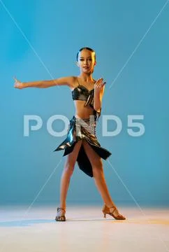 Rumba dance. Beautiful little girl in stage attire dancing latino madern Stock Photo #236009345