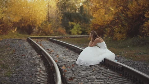 Runaway bride. sad girl sitting on rails... | Stock Video | Pond5