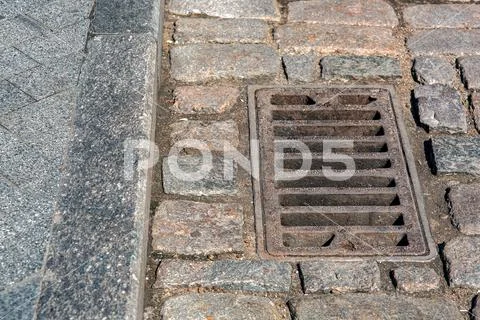 Rusted rectangular grating manhole drainage system on the pavement road ...