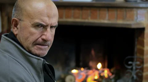 sad and angry old man near the fire in t... | Stock Video | Pond5