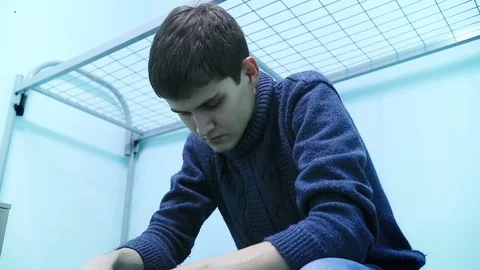 A sad and malicious young prisoner in a ... | Stock Video | Pond5