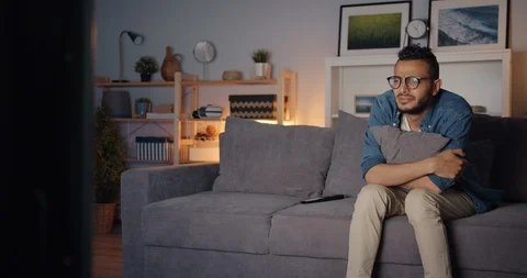 Sad Arabian guy watching TV crying wipin... | Stock Video | Pond5