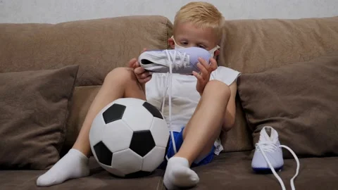 Sad boy in mask sitting on the sofa with... | Stock Video | Pond5
