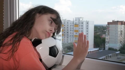 Sad child with ball by window. | Stock Video | Pond5