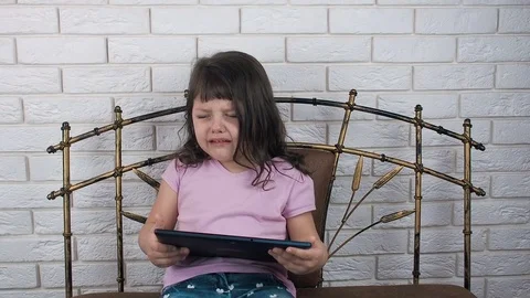 Sad child with a tablet. A little girl w... | Stock Video | Pond5