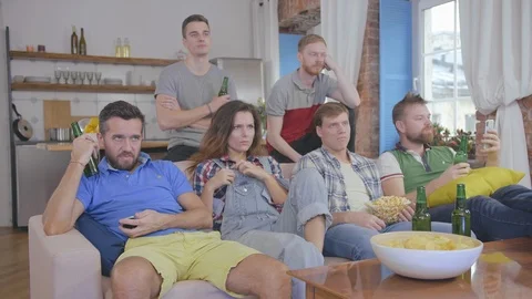 Sad friends watching TV at the boring ho... | Stock Video | Pond5