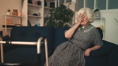 Sad grandma looks at walking frame while... | Stock Video | Pond5