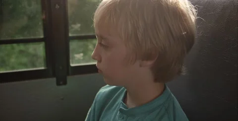 Sad kid sitting on school bus - blonde b... | Stock Video | Pond5