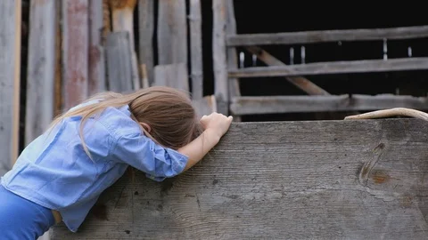 Sad little girl in blue clothes piled on... | Stock Video | Pond5