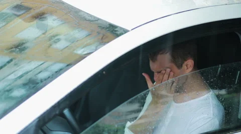 sad man crying in the car. rain on the s... | Stock Video | Pond5