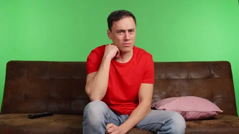 Sad man crying watching a movie on green... | Stock Video | Pond5